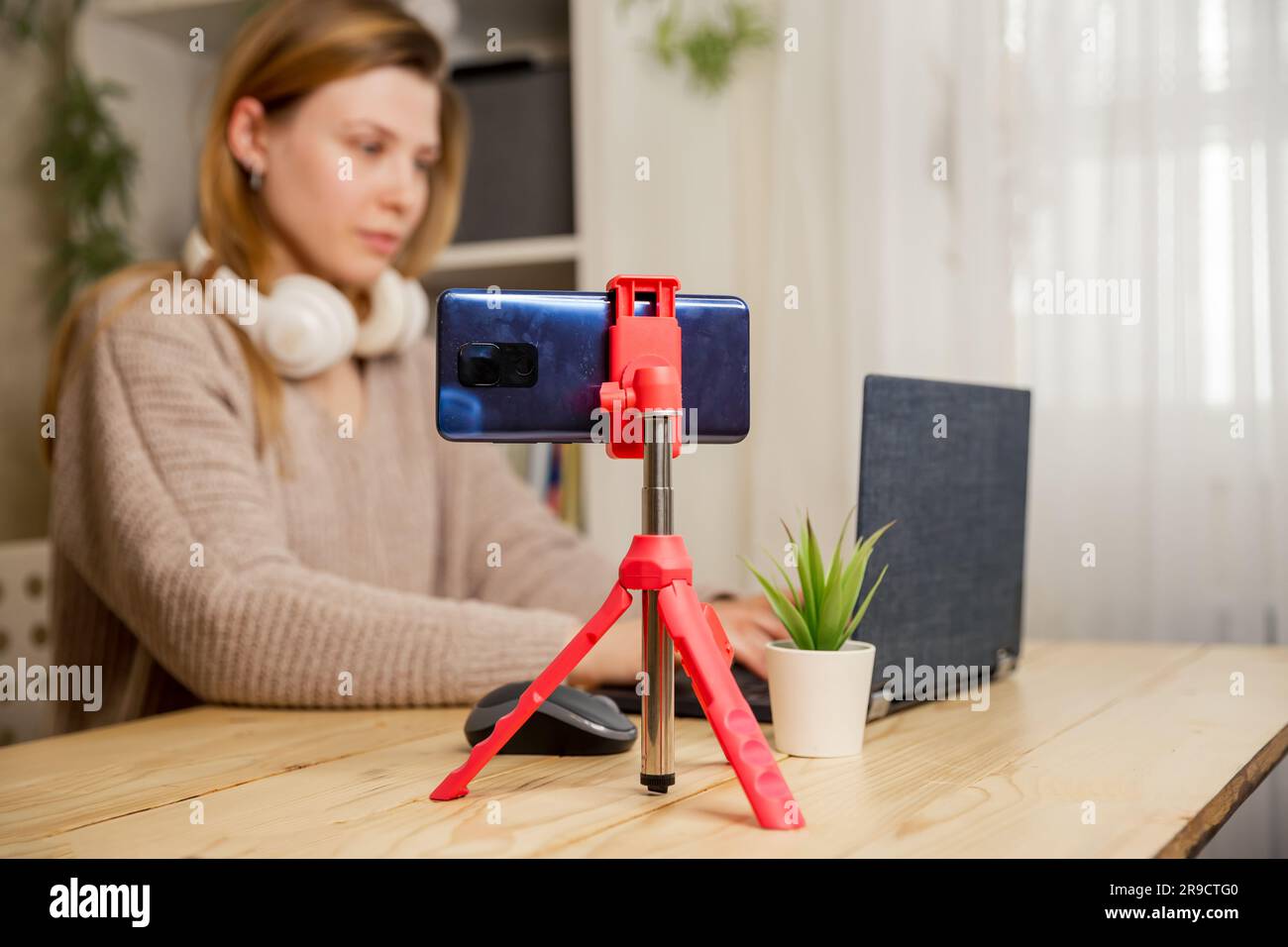 Female influencer vlogging online with smartphone cam and laptop Stock ...