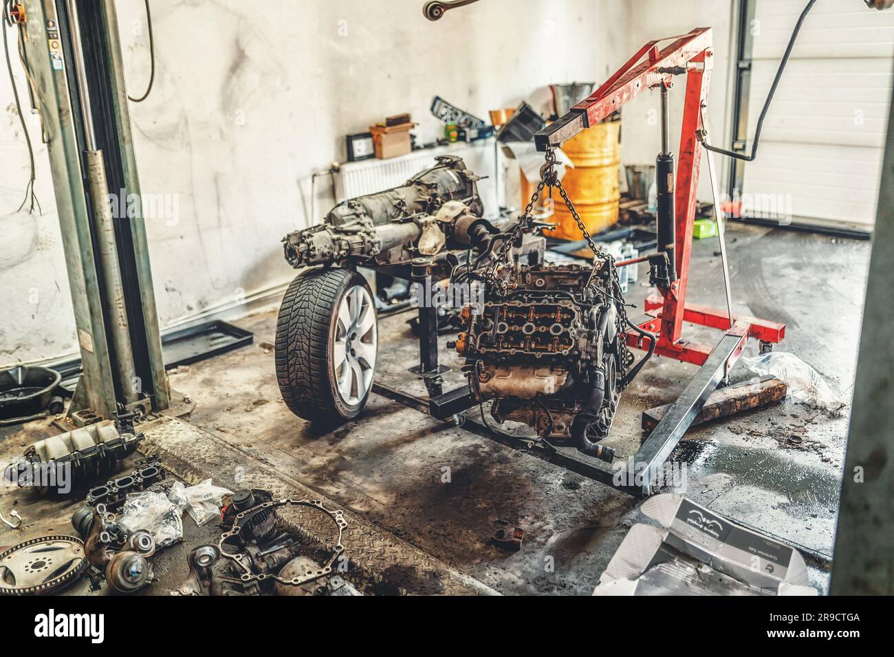 disassemble the engine from the car in the car workshop Stock Photo - Alamy