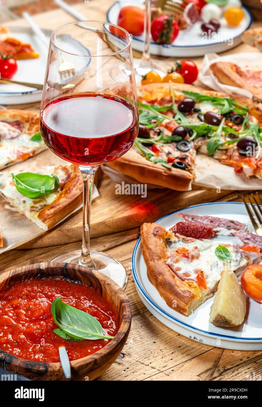 Pizza party dinner table. Glasses with red wine and plates, rustic ...