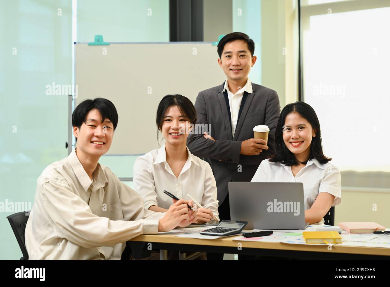Group of company employees sitting in modern office and smiling ...