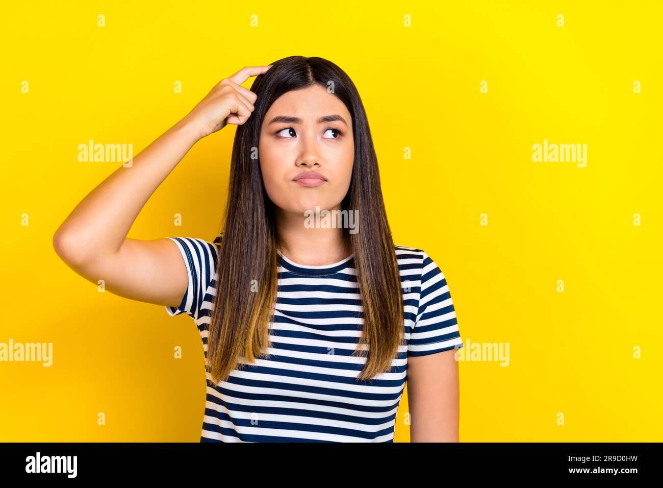 Photo of doubtful unsure lady wear striped dress finger head looking ...