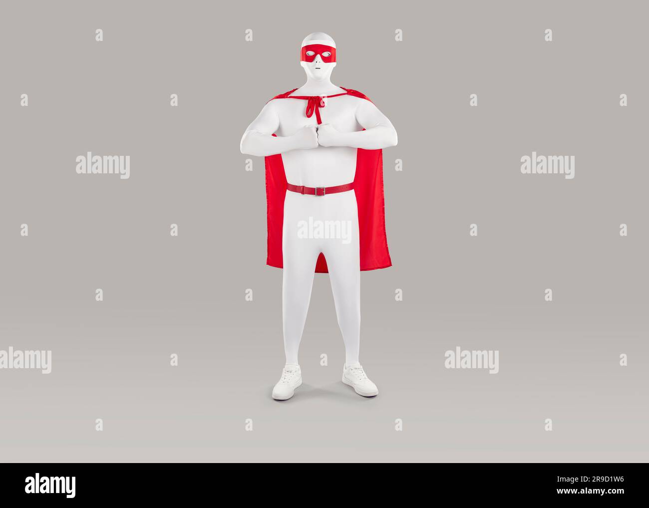 Man in red superhero cape, red eye mask and white bodysuit standing on ...