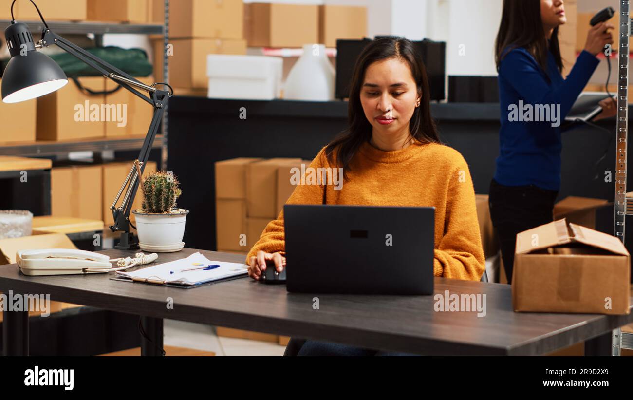 Small business owner planning order distribution on pc, checking stock logistics before sending ...