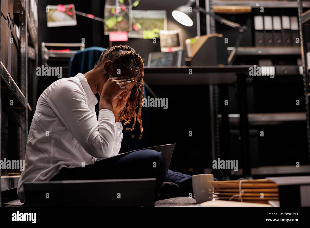 Tired police detective having headache while working late and analyzing ...