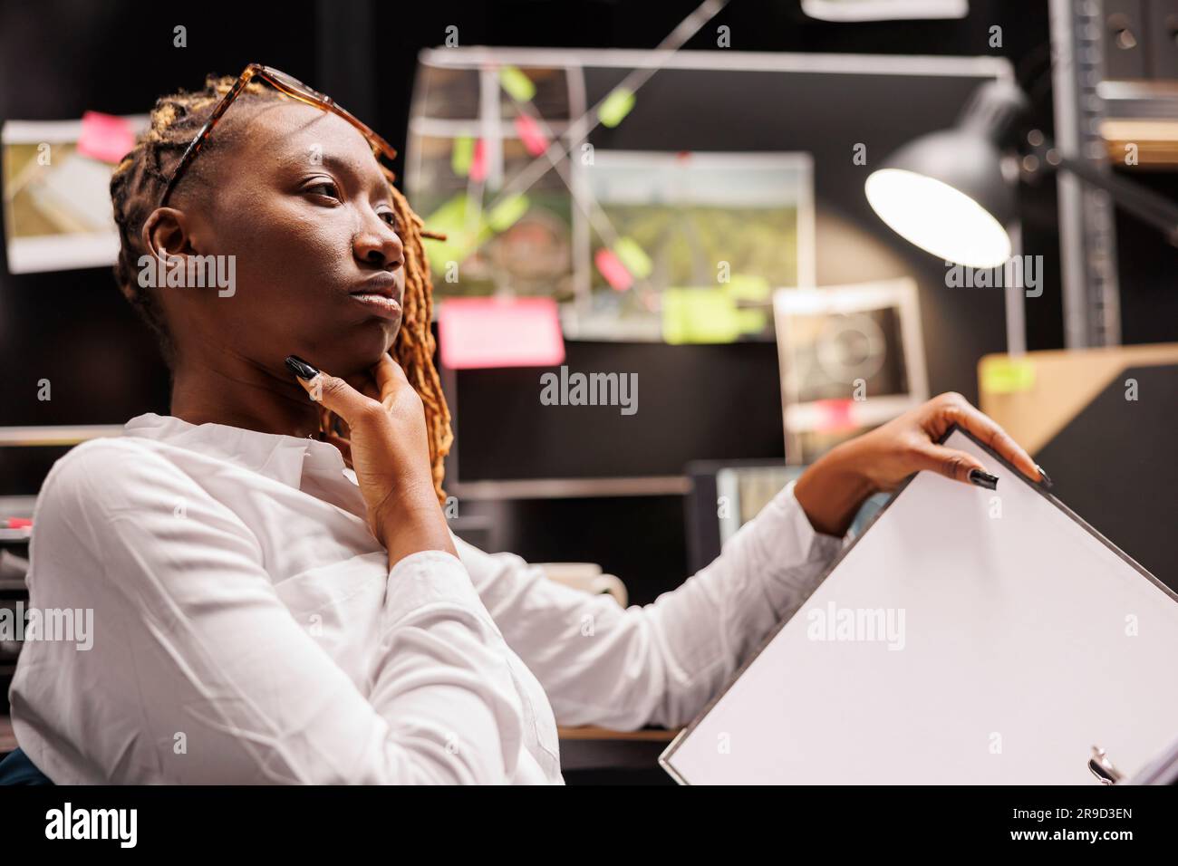 Thoughtful African American Woman Detective Analyzing Crime Case File