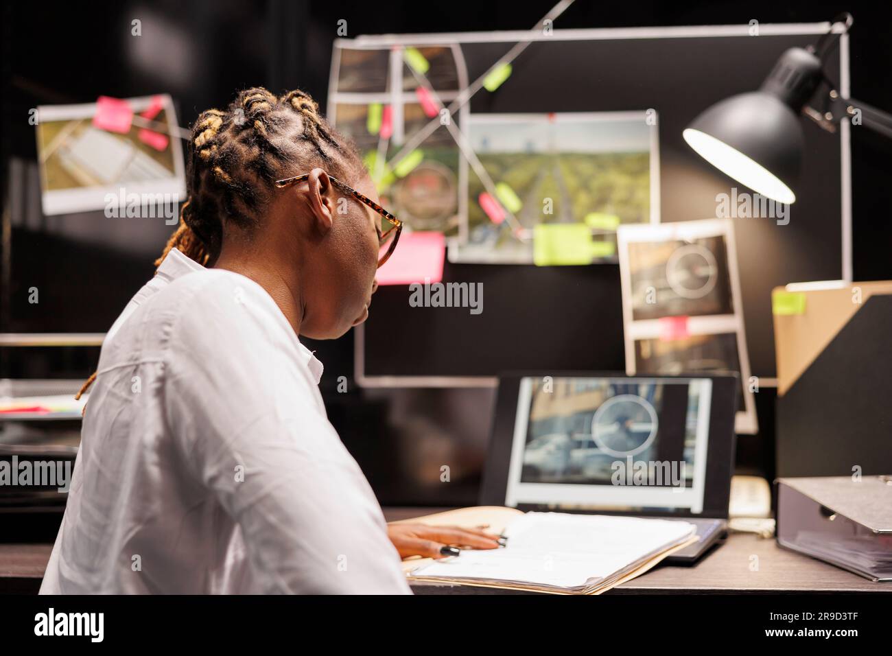 Police Detective Reading Records In Crime Case File While Working Overtime In Office African