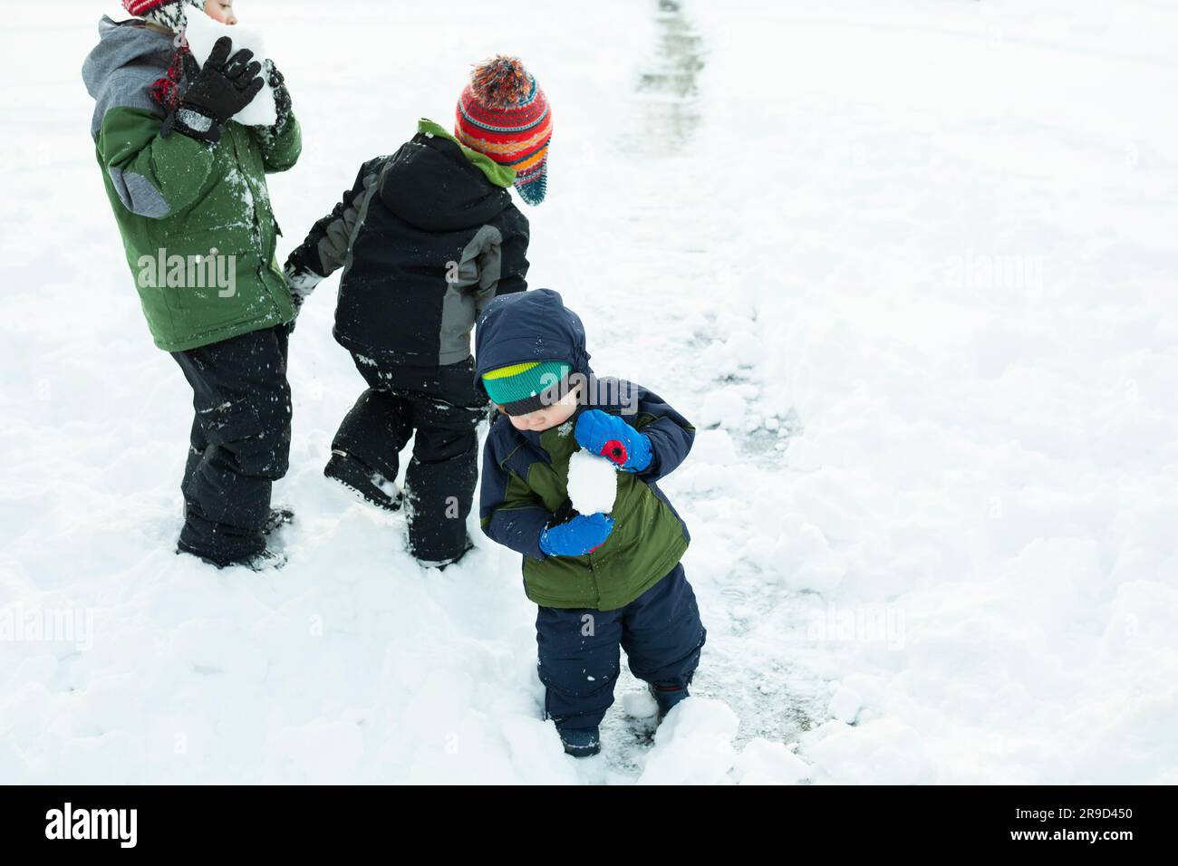 Three brothers play outside making snowballs after winter storm Stock ...