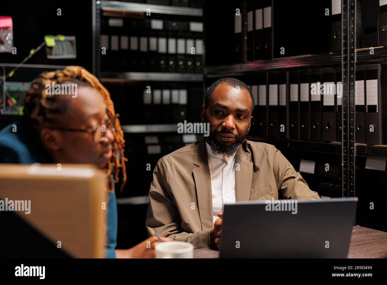 African american policewoman helping detective with evidence analysis ...