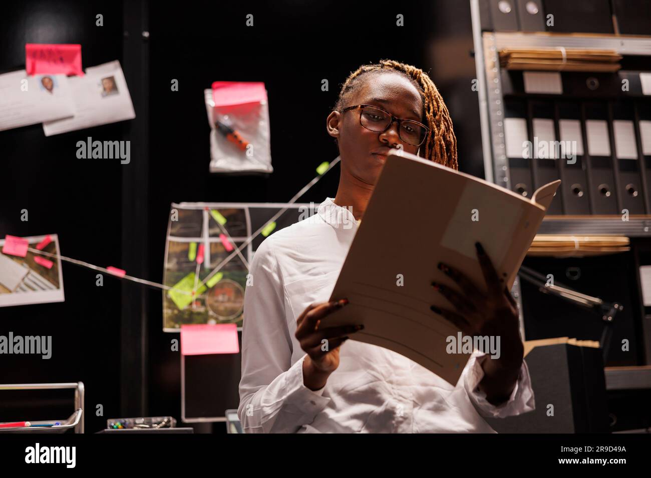 African american woman reading crime case file in detective office room ...