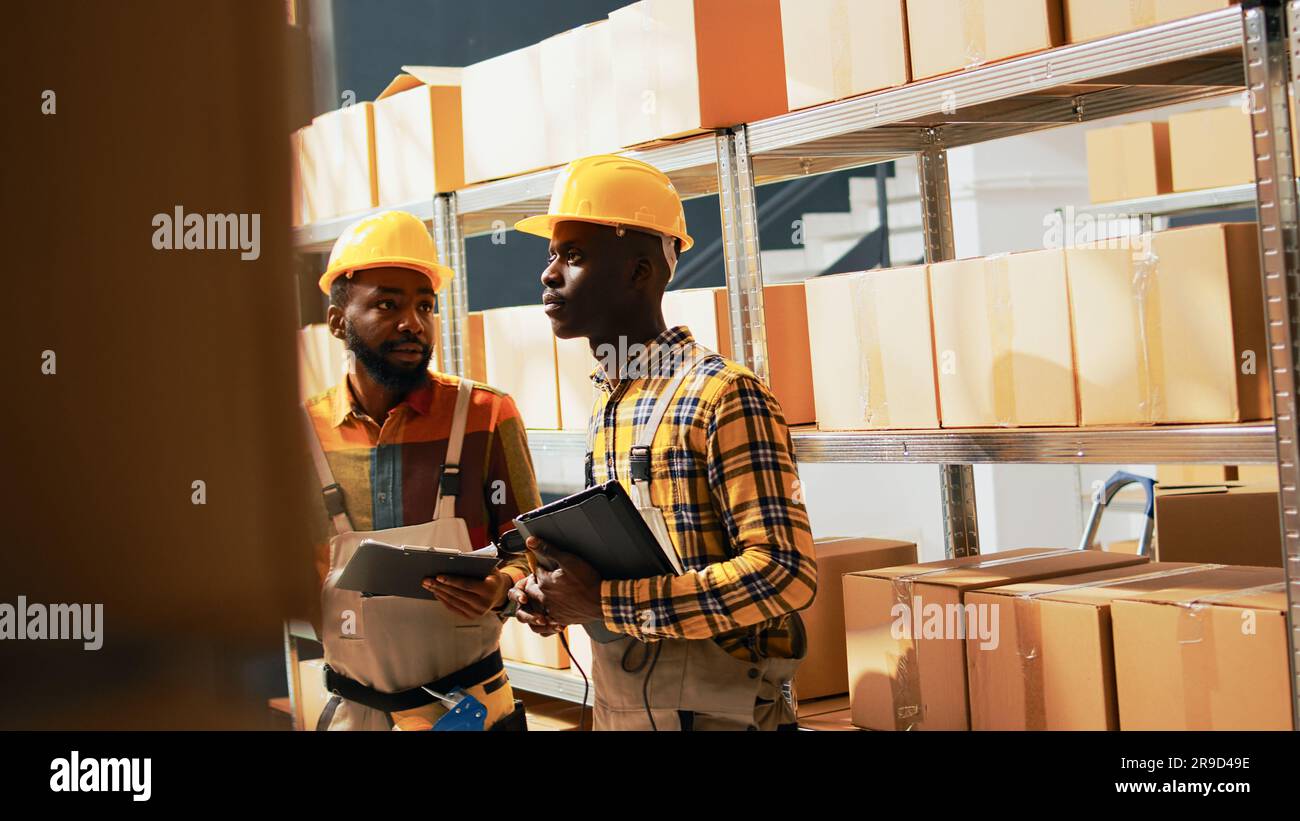 African american men planning stock distribution with cargo on racks ...