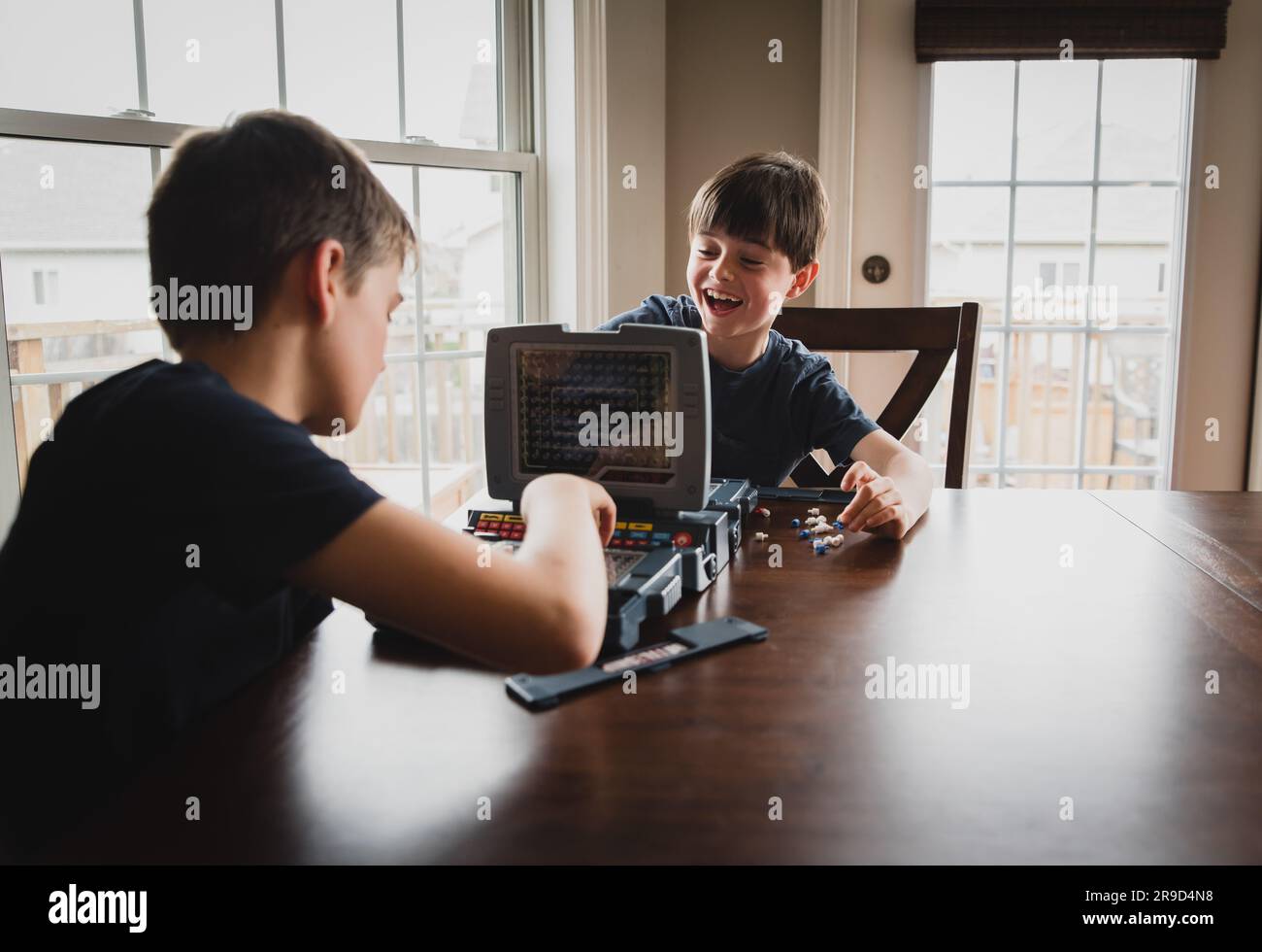 Boy laughing at his brother as they play a board game together Stock ...