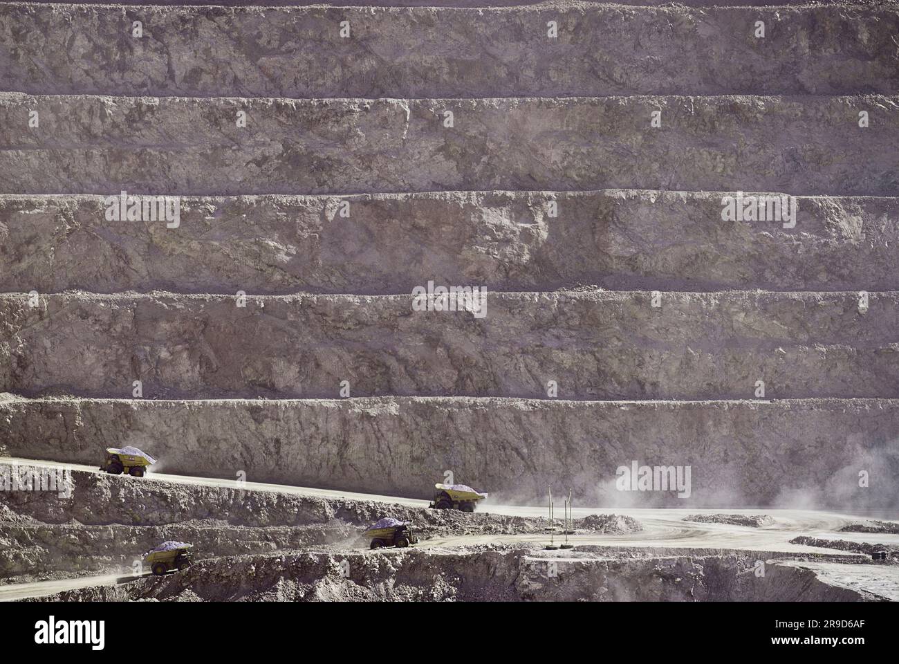 Haul trucks ascending open-pit mine Stock Photo - Alamy
