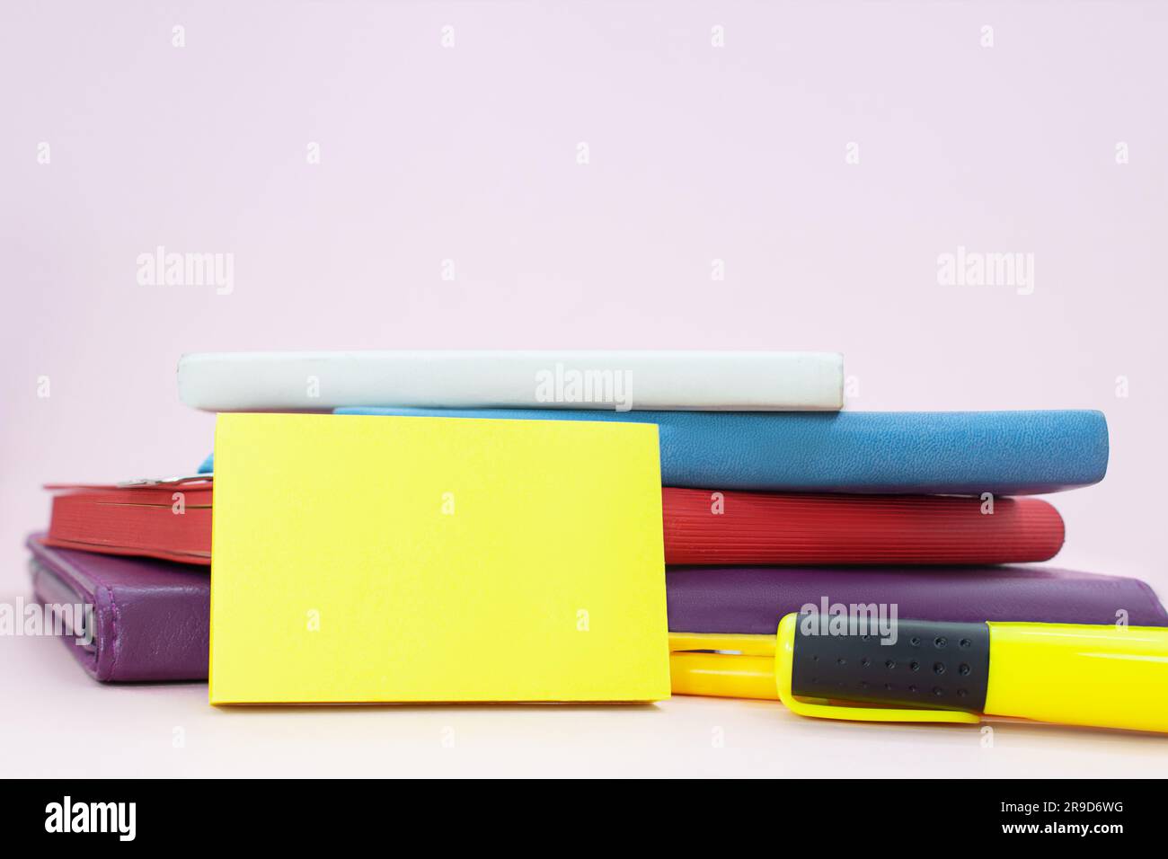 Stack of notepads with marker on pink table with sticky sticker. Back ...
