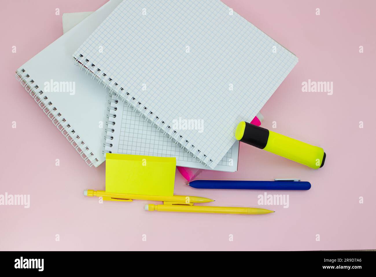 Notebooks with pens, markers and stickers on a pink background. Back to ...