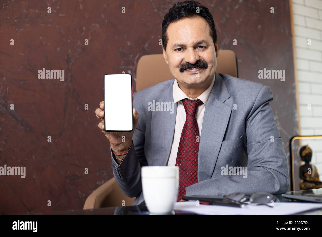 Happy indian businessman sitting in office wearing suit showing smart ...