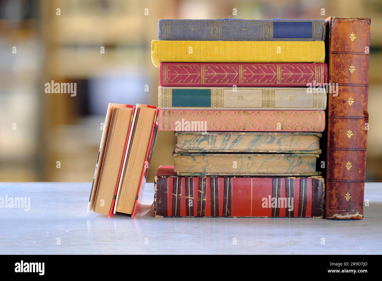 Stack of books with blurred bookshelf background, reading, learning ...