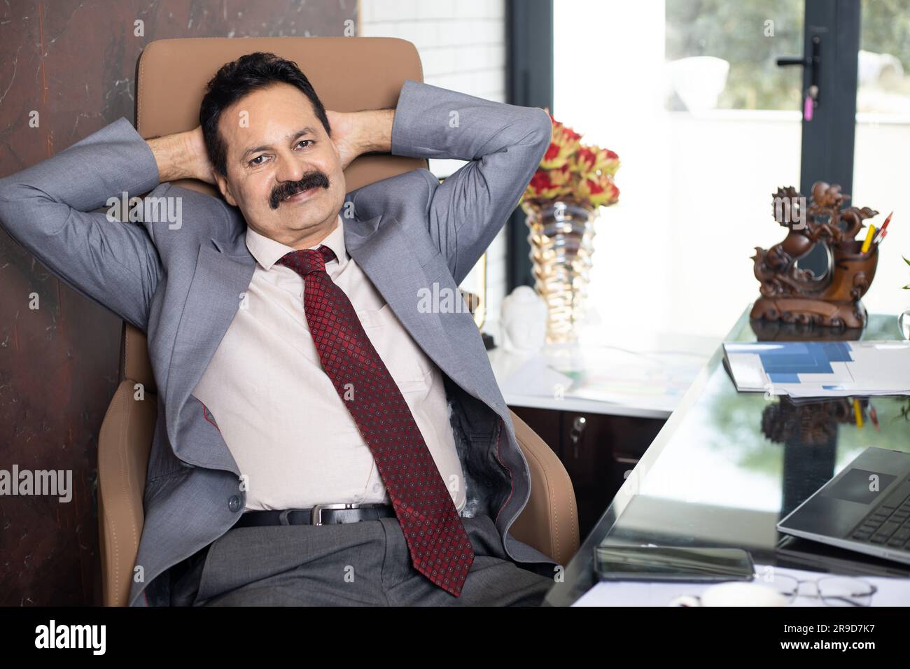 Mature indian business man sitting relaxing on chair in office, resting ...