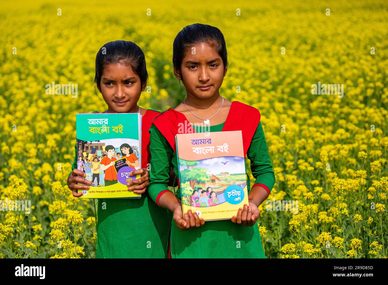 Bangladeshi primary school girls hold new textbooks after receiving ...