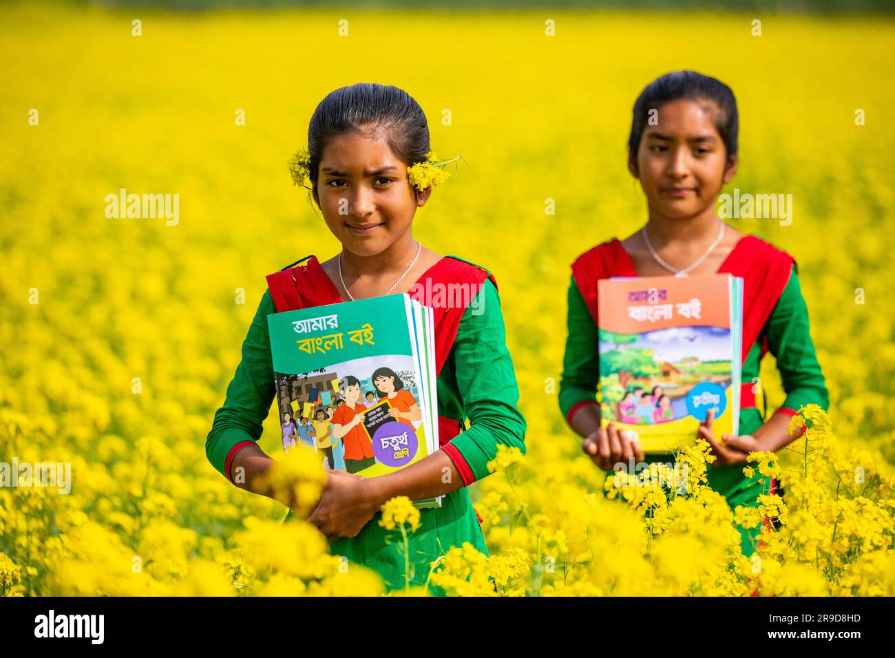 Bangladeshi primary school girls hold new textbooks after receiving ...