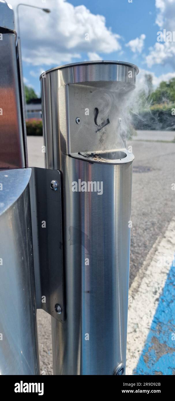 Smoke rising from inside metal cigarette disposal bin caught on fire ...