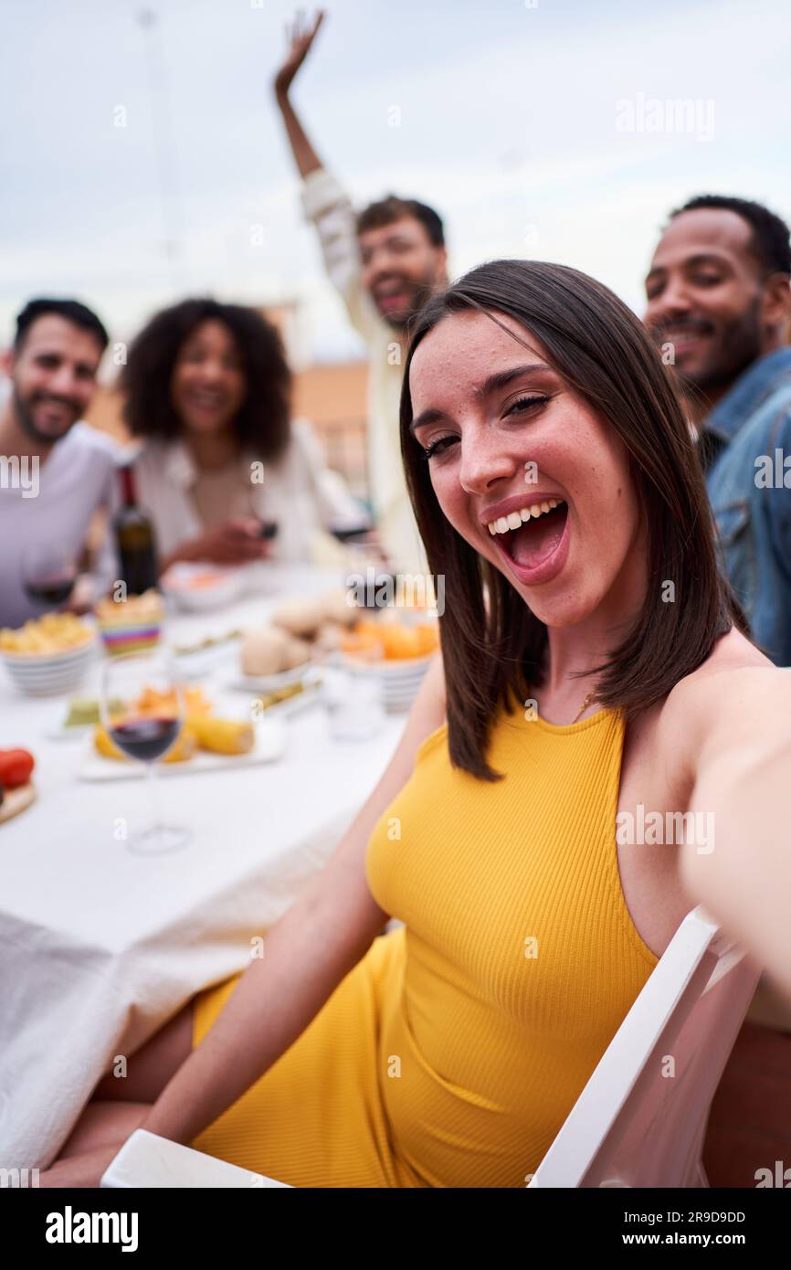 Group of multiethnic friends taking a selfie during social gathering in ...