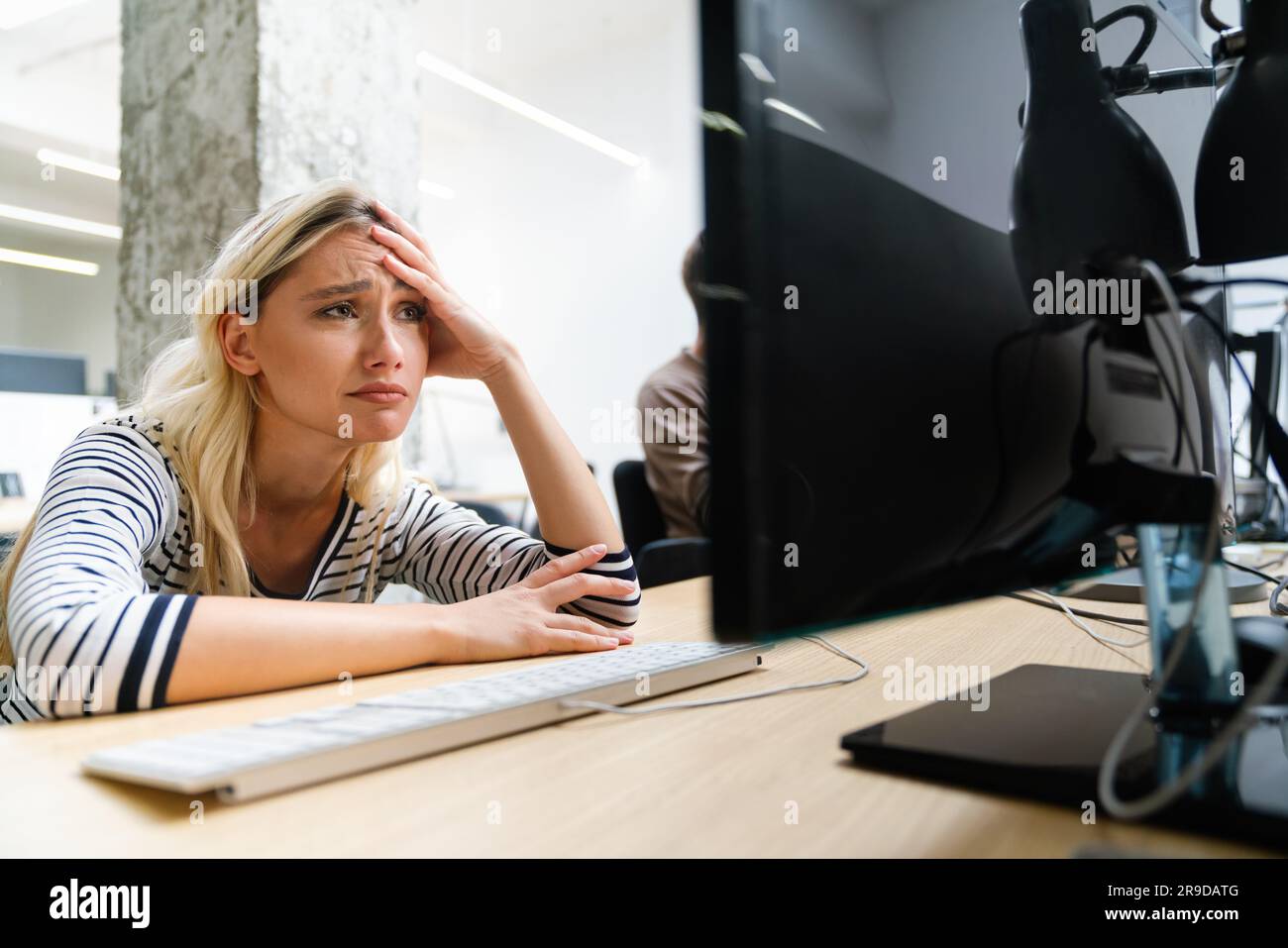 Portrait of a disappointed woman programmer looking stressed out while ...