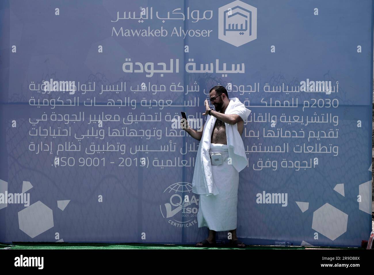 A Muslim pilgrim makes a video call with his family at Mina tent camp ...