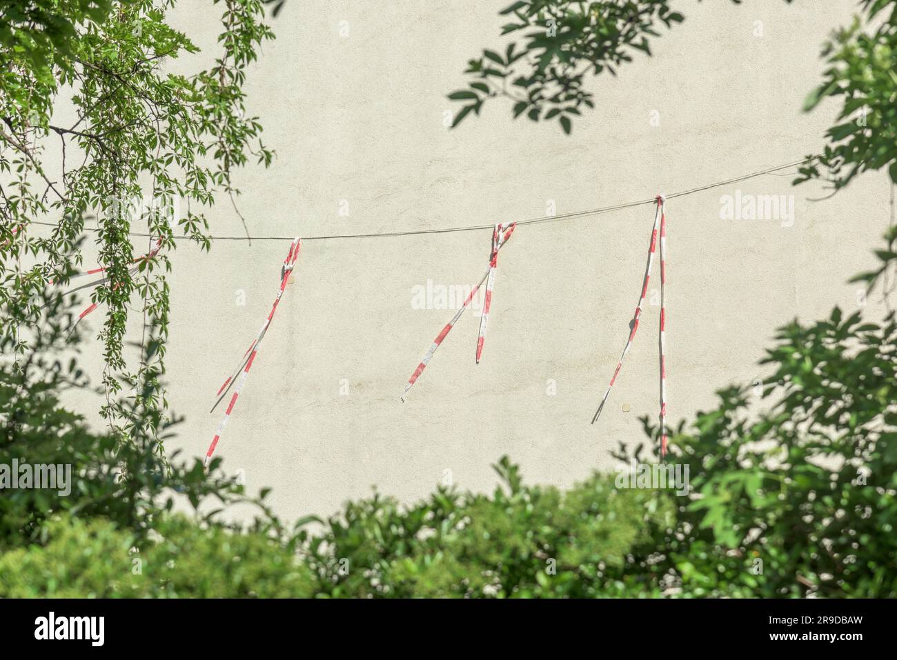 Barrier tape on a line in front of a house facade with green border ...