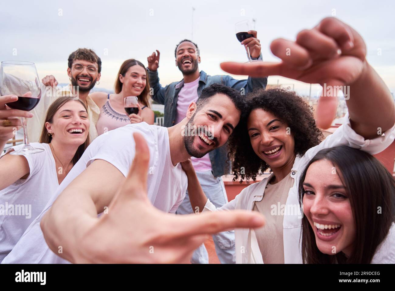 Happy selfie of mixed race group of friends making frame gesture with ...