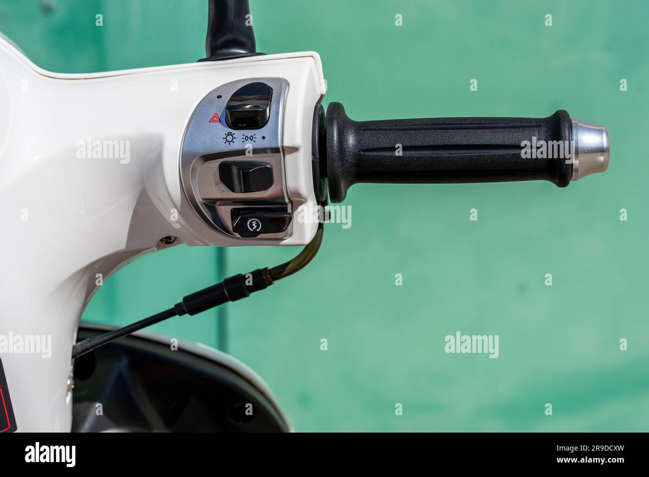 The throttle control knob and lighting fixtures on the handlebars of ...