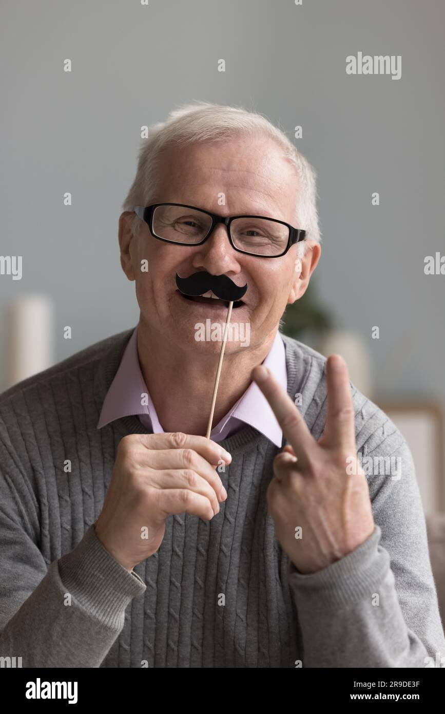 Vertical portrait carefree senior man having fun hold party accessory ...