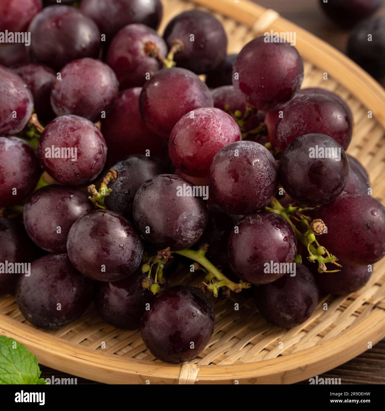 Delicious bunch of purple grapes fruit on a tray over wooden table ...
