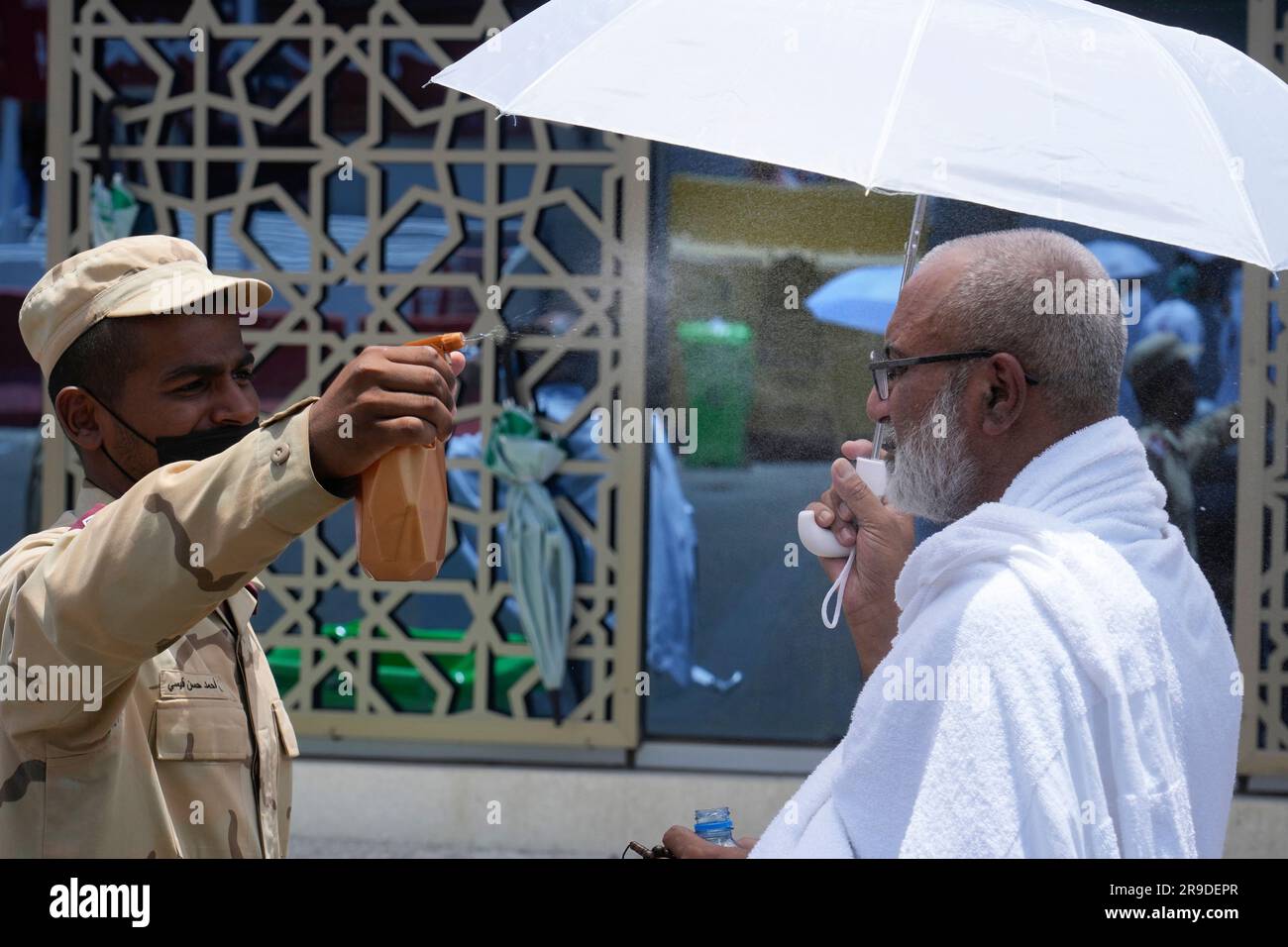 A police officer sprays cold water on a Muslim pilgrim at the Mina tent ...