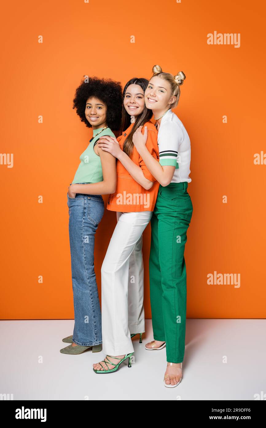 Full length of trendy multiethnic teenagers with bold makeup wearing ...