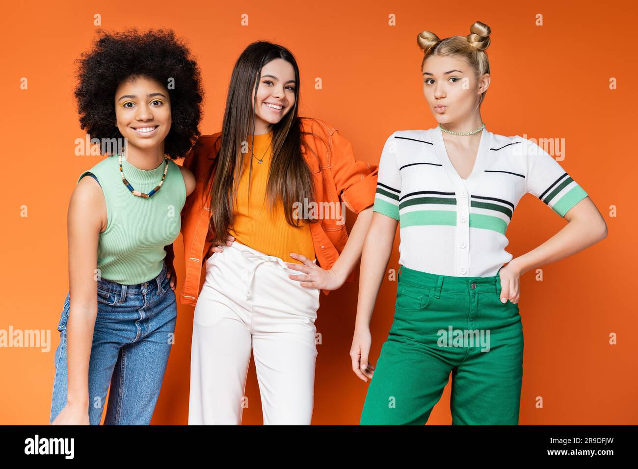 Cheerful and multiethnic teenagers with bold makeup posing in trendy ...