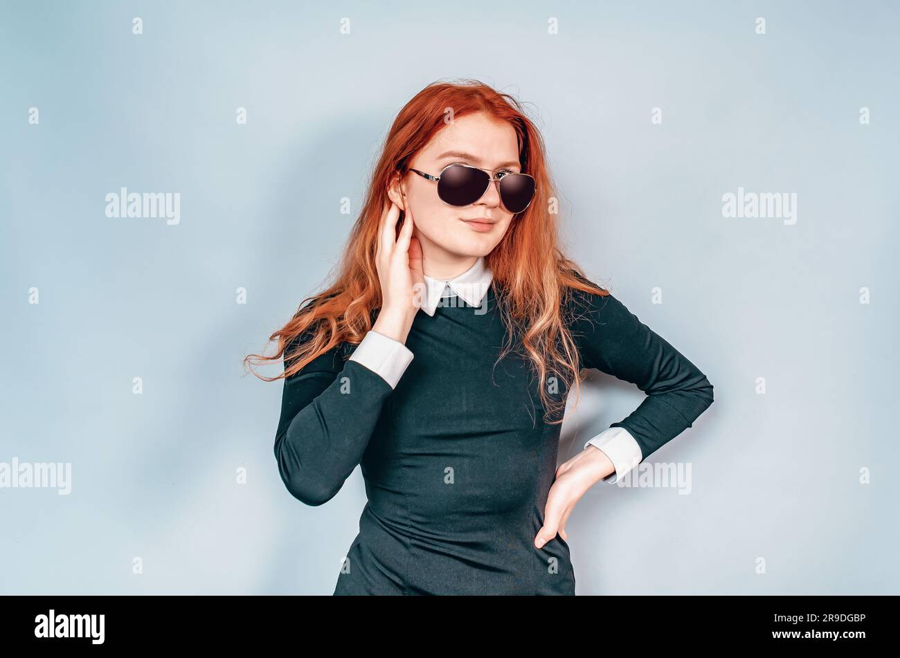 Stylish woman holds black glasses with hand. Black strict dress with a ...