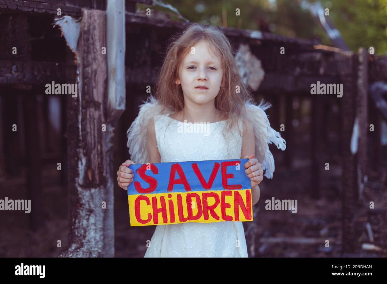 A girl with a poster in her hands asks to protect children. It is ...