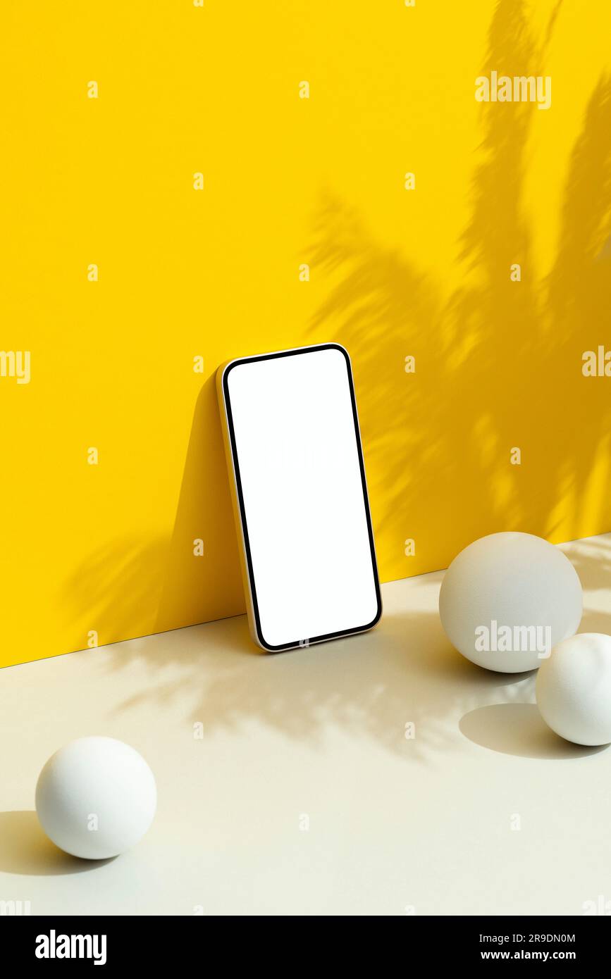 Mobile phone mockup leaning on yellow background with white spherical ...