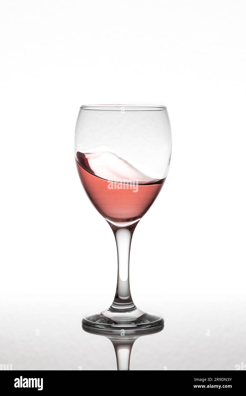 Motion glass of rose wine isolated on a white background over a ...