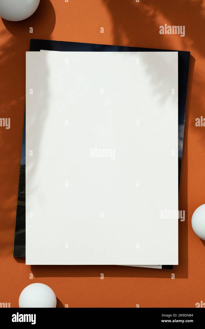 Blank white magazine cover mockup on brown background. High angled shot ...