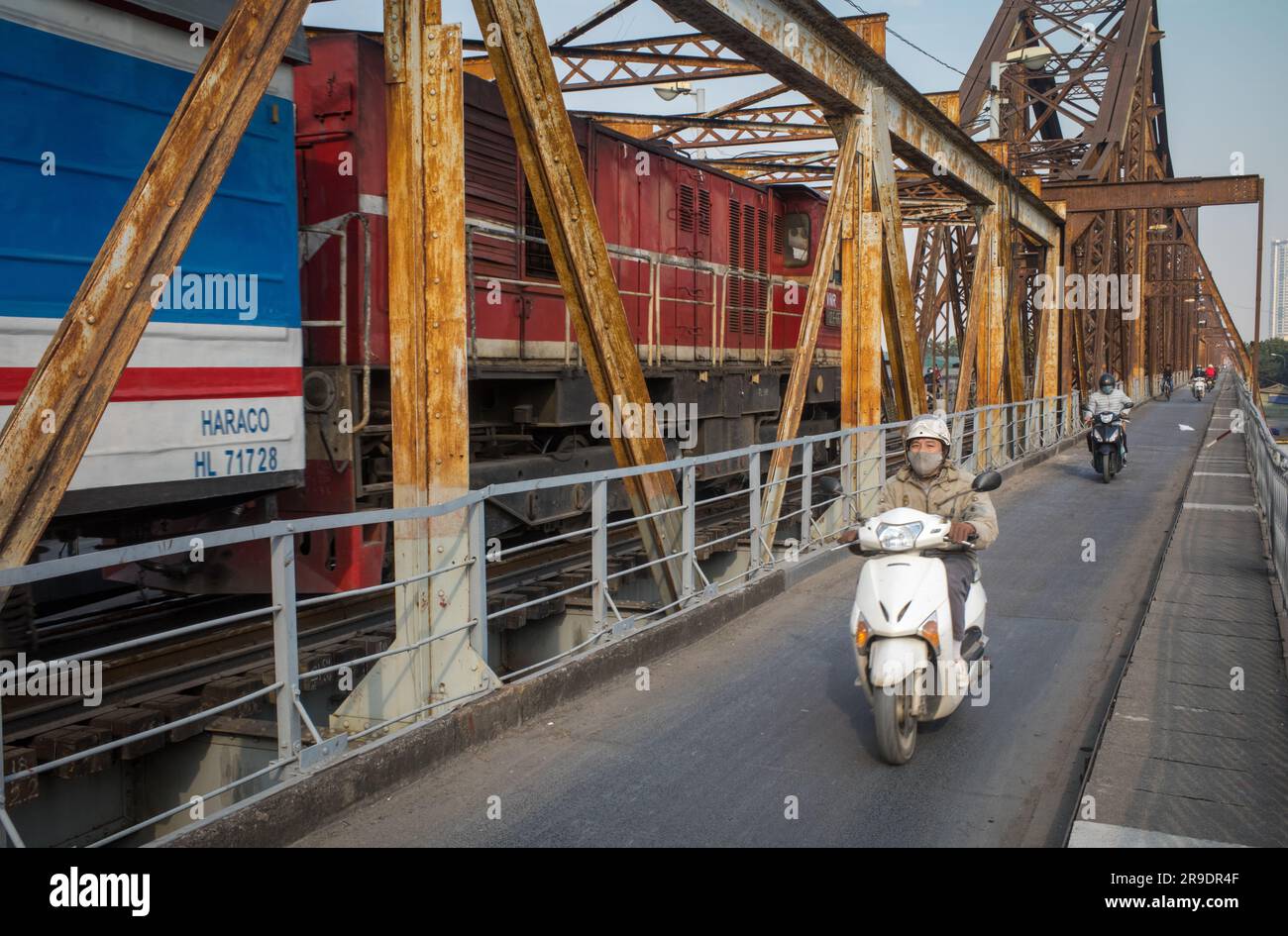 A Vietnam Railways train passes motorcycle traffic on the famous Long ...