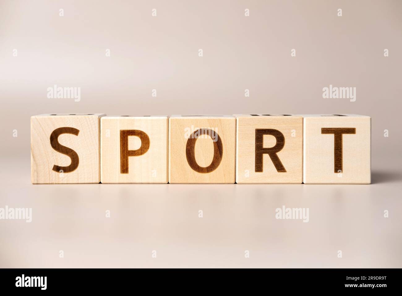 The word SPORT on wooden cubes on a beige neutral studio background ...