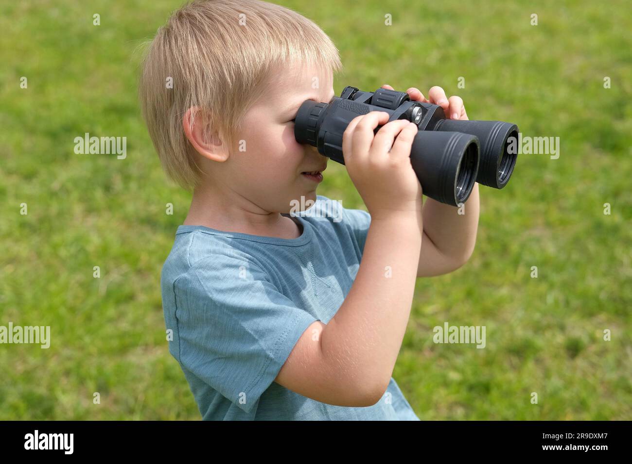 Little Boy using binoculars in a forest. 4 years kid looking ahead ...