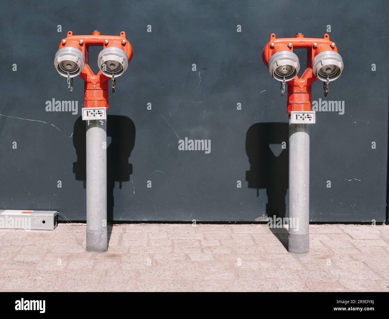 Two red fire hydrants side by side against a grey background Stock ...