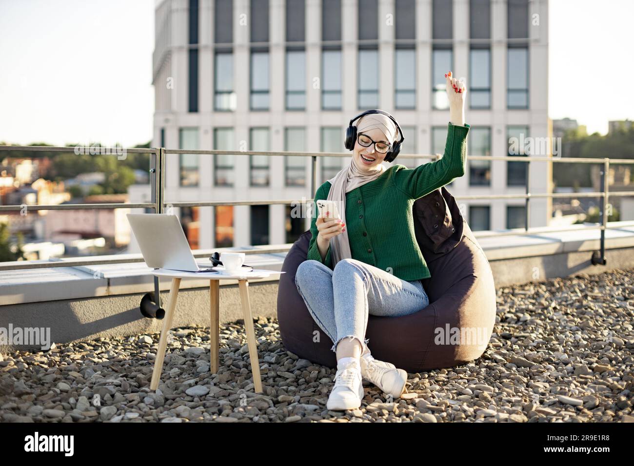 Emotional muslim lady in hijab singing along musical phrases in ...