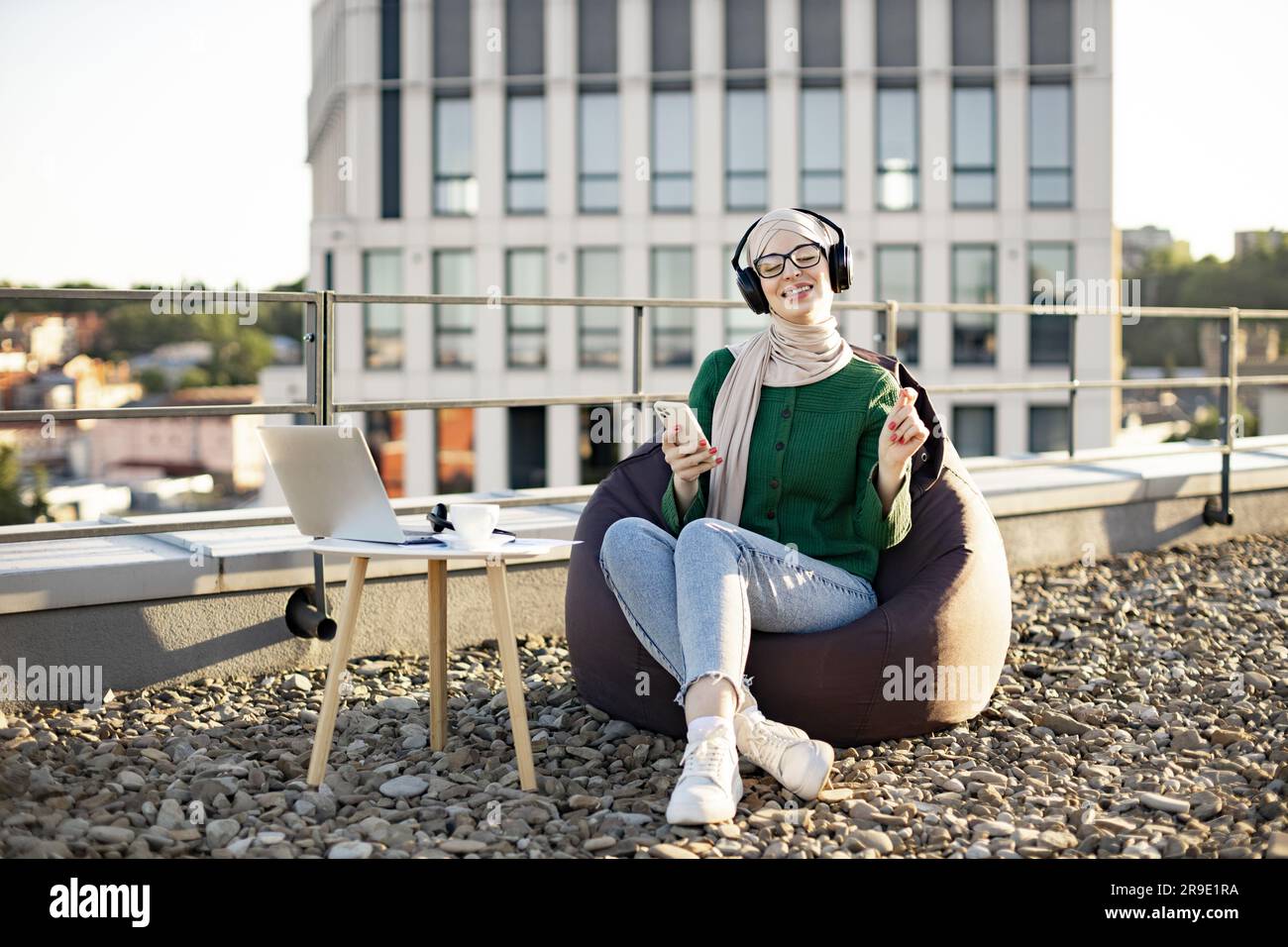 Emotional muslim lady in hijab singing along musical phrases in ...