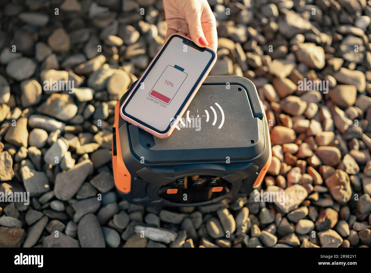 Stylish smartphone with red battery on screen being held by female ...