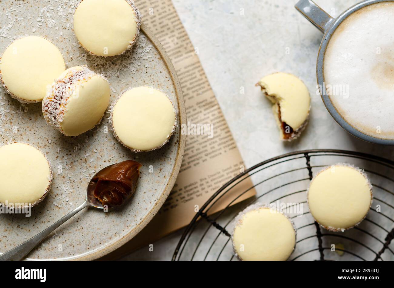 Cornstarch alfajores with milk caramel and coconut on a beige plate and ...