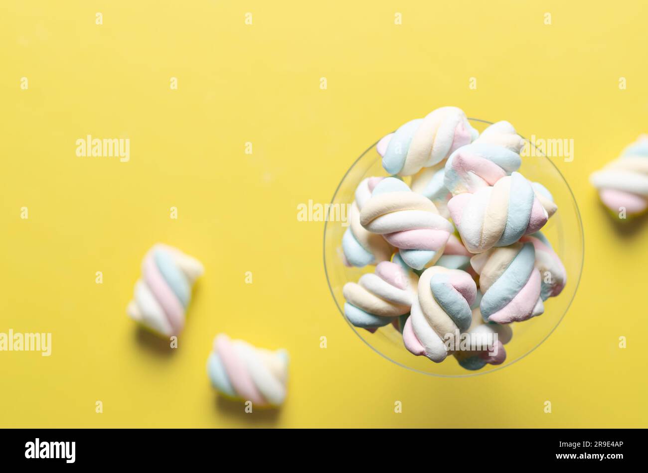 White, yellow, pink, and light blue marshmallows on yellow background ...