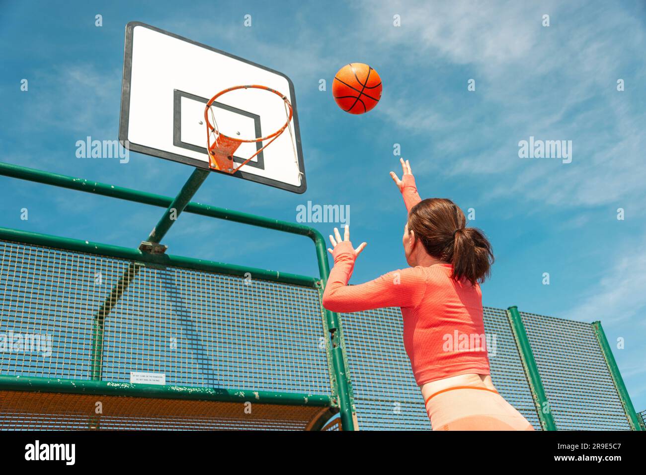 Female basketball player about to throw at the hoop. Outdoors in the ...